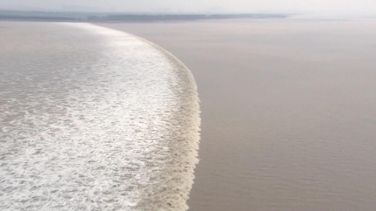 Onrushing tidal bore hitting onto Laoyancang dam - CGTN
