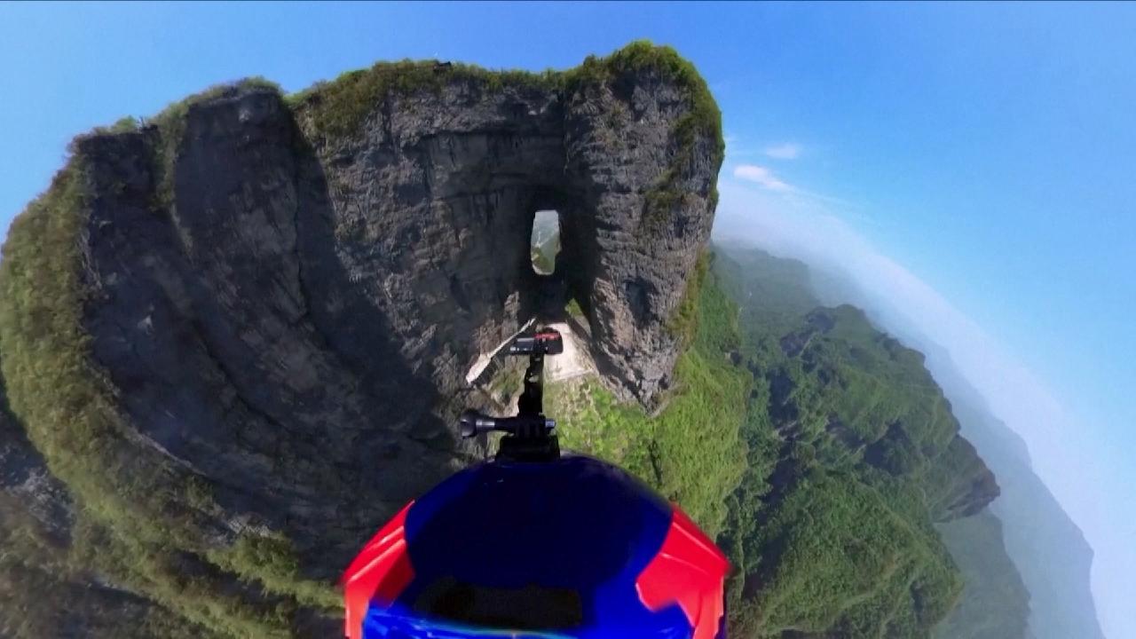 Chinese wingsuiter flies through Tianmen Cave for first time - CGTN