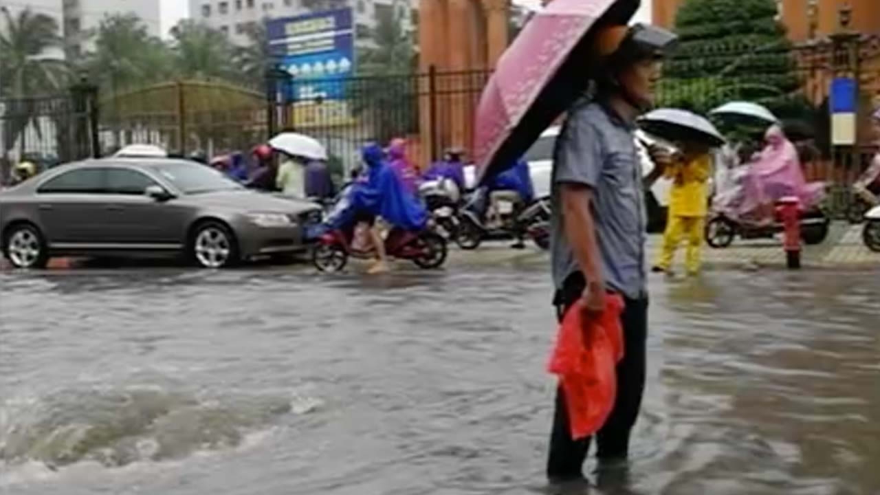 Good Samaritan guards manhole during a storm in Hainan Province - CGTN